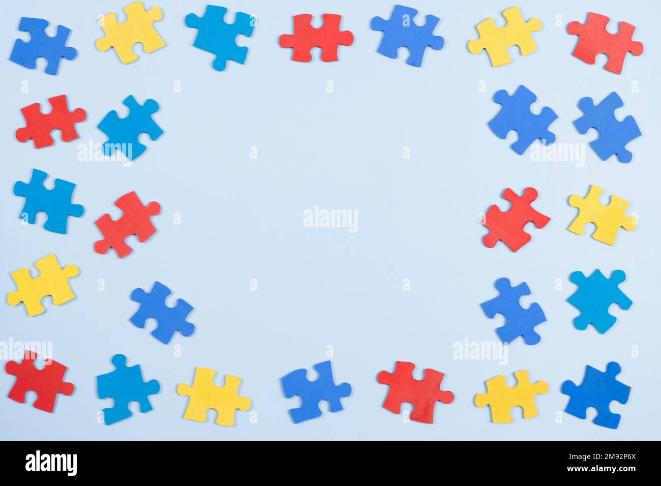 Blue, yellow, red pieces of puzzle on light blue frame background ...