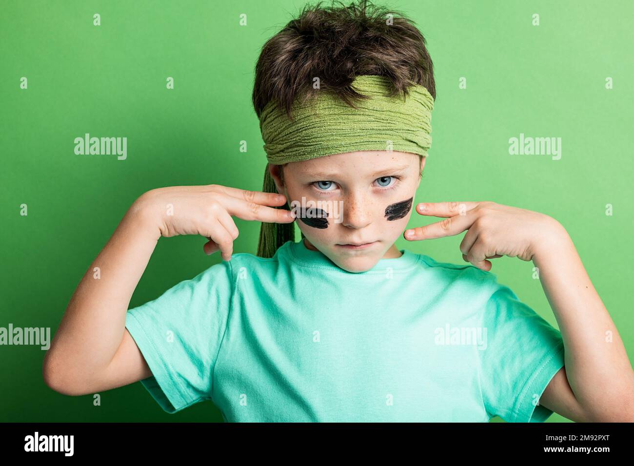 Kid in casual clothes with green headband drawing black strips with ...