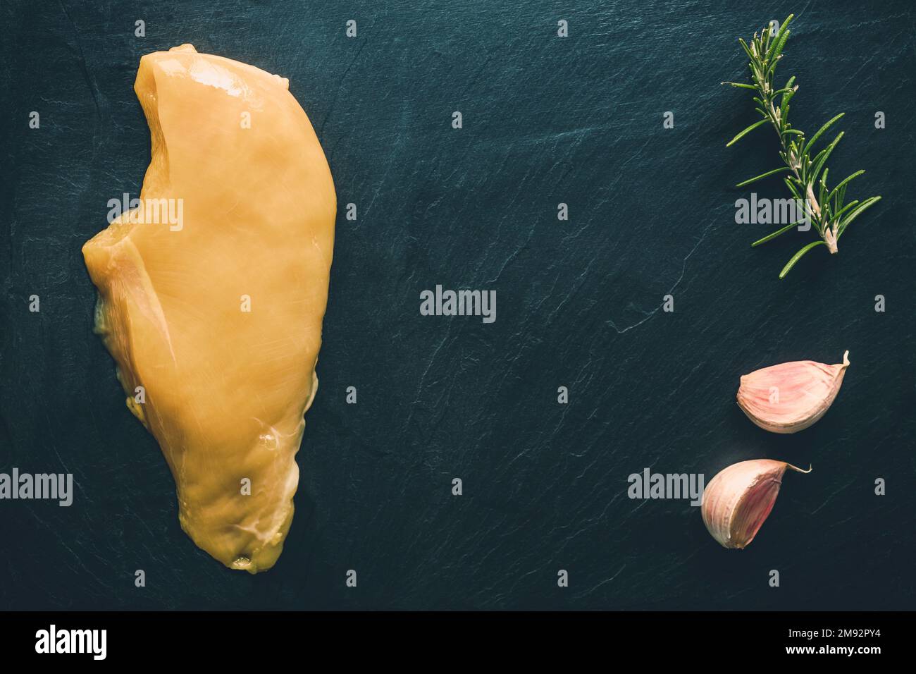 From above composition of raw fresh chicken fillet placed on black ...