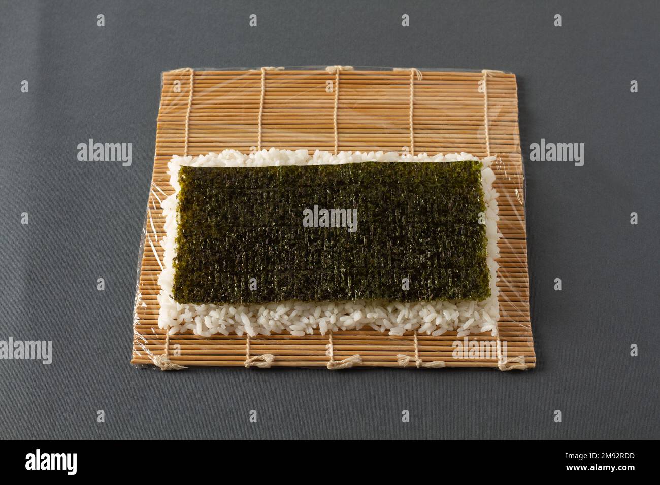 Rolling mat consisting of seaweed rice during sushi preparation Stock ...