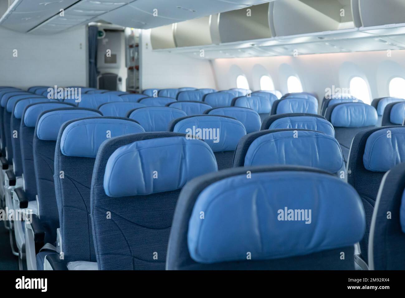 Interior of empty modern aircraft with blue flight seats and hallway in ...