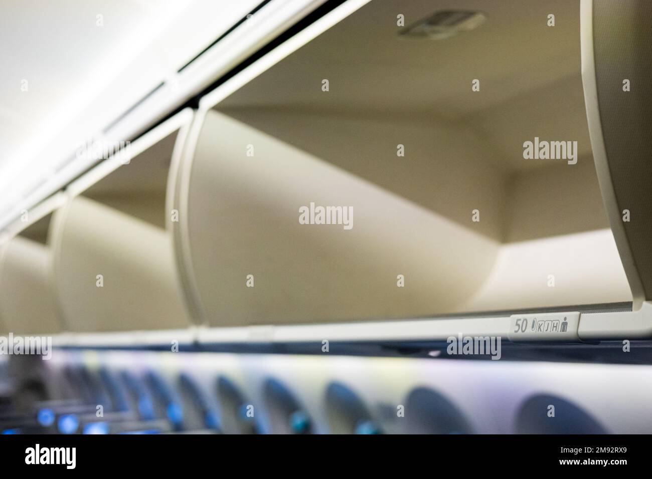 Modern interior of spacious airplane with empty luggage racks placed ...
