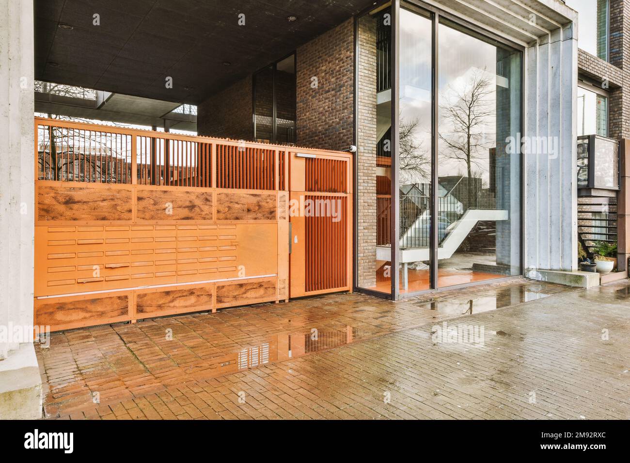 Gate and fence with mail boxes located near wet pavement outside ...