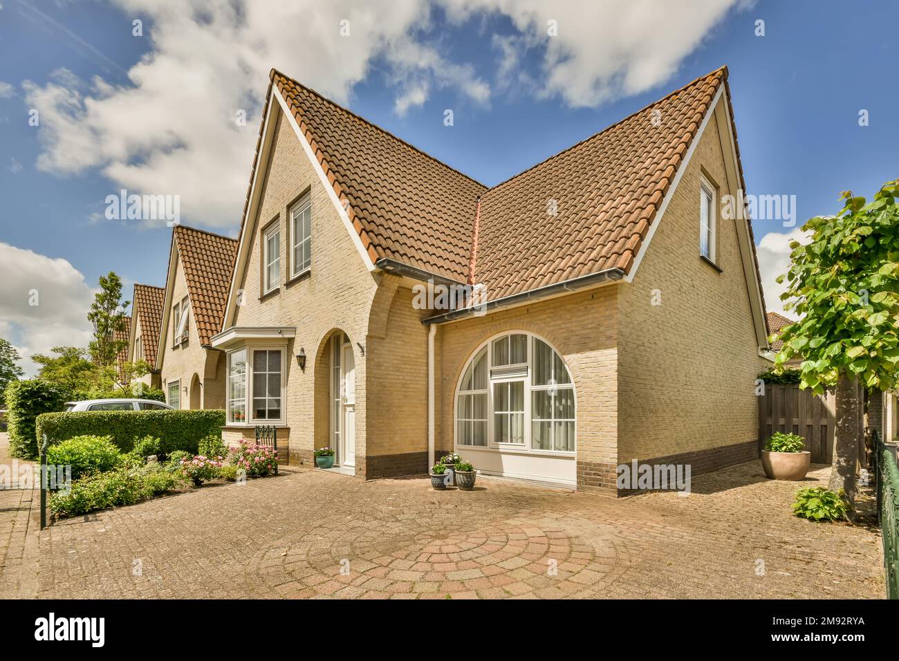 View of a street with houses lined up under a blue sky with clouds ...