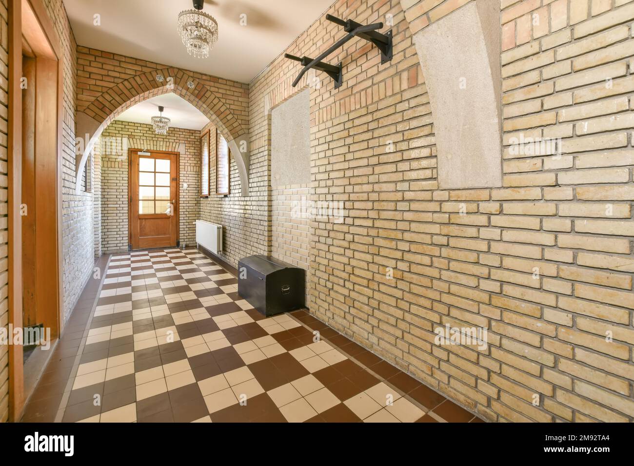 Interior passage way in a house with windows and brick wall Stock Photo ...