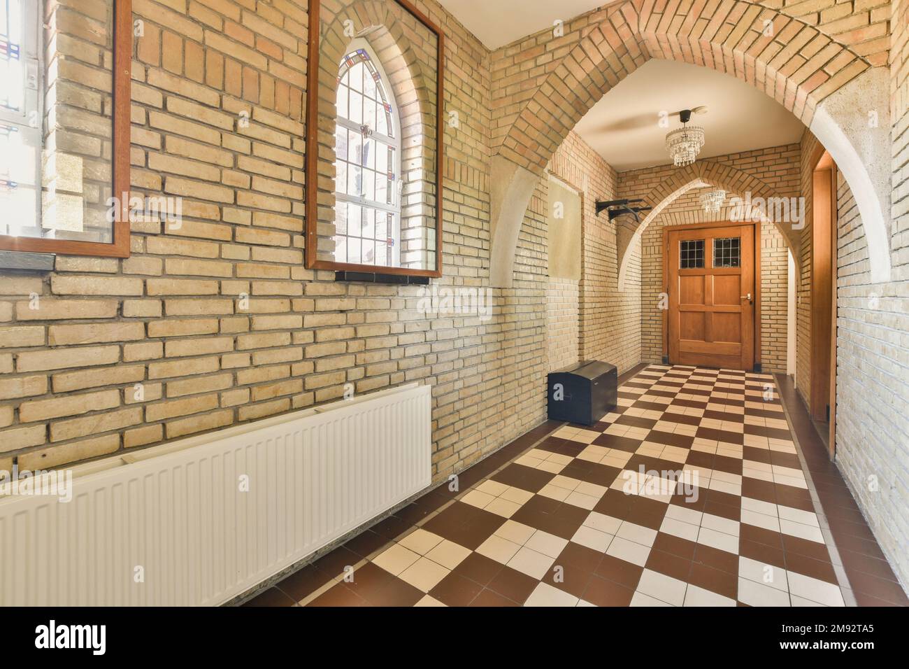 Interior passage way in a house with windows and brick wall Stock Photo ...