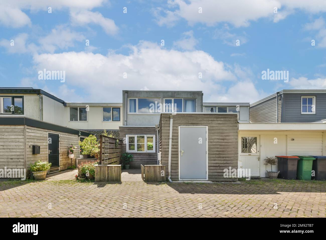 Front view of a street with houses lined up under a blue sky with ...