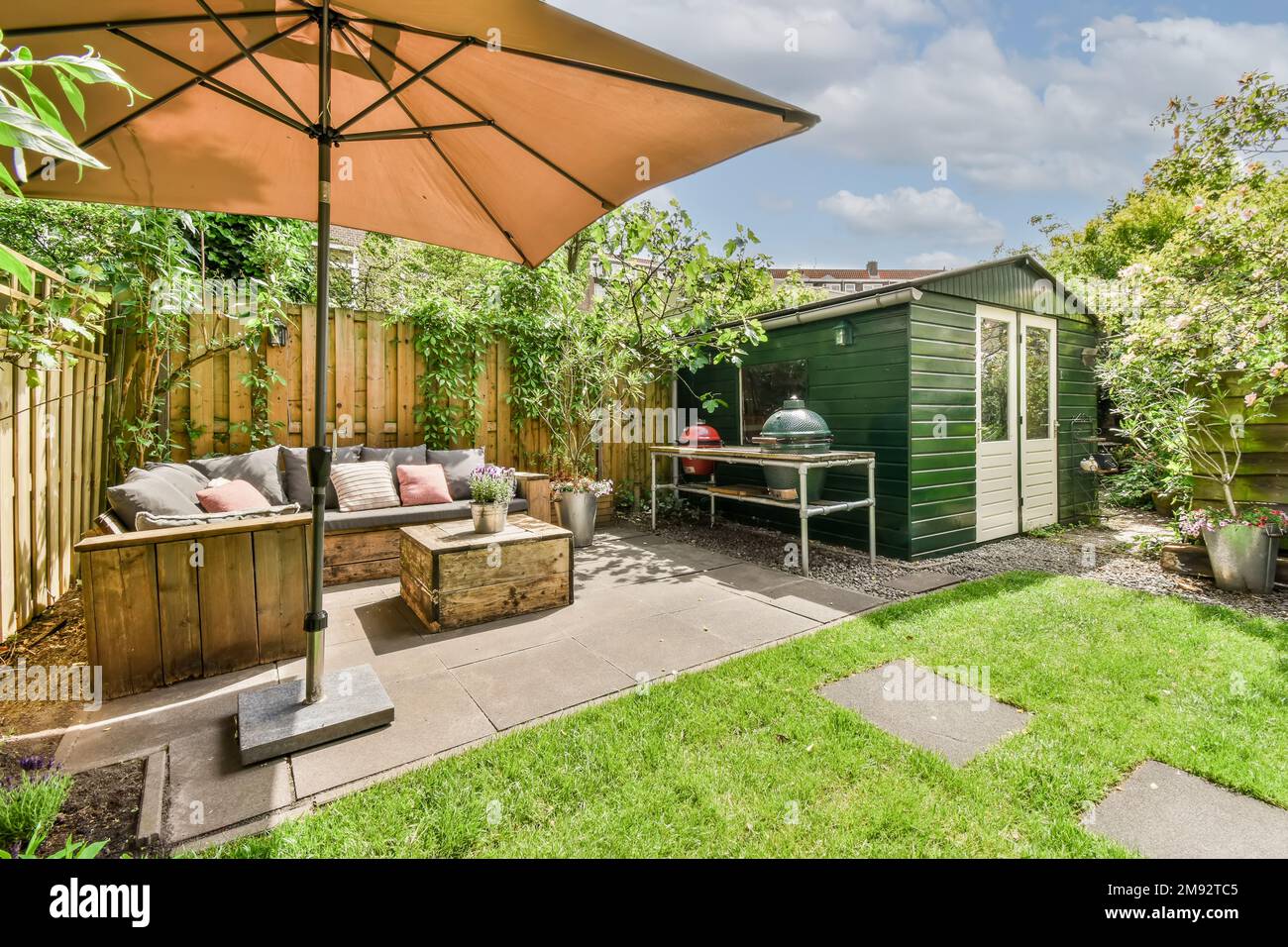 Terrace of residential building with green lawn and sofas on placed ...