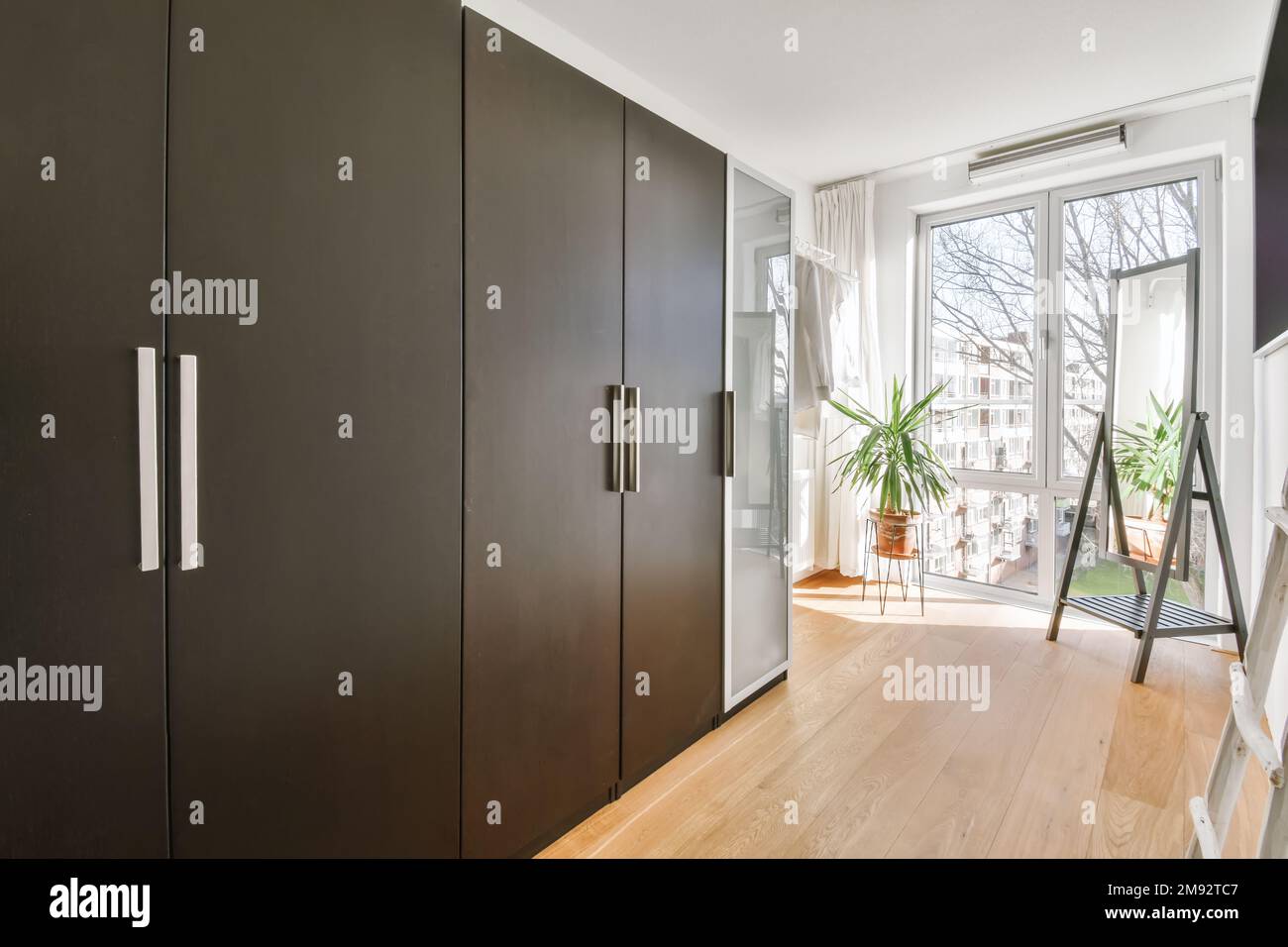 Interior of modern living room with big closet and panoramic window on ...
