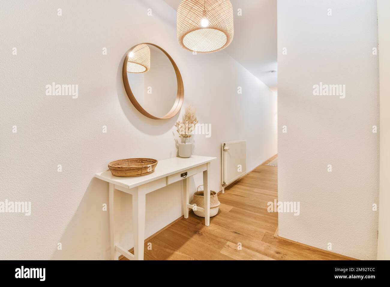 Modern light corridor with round mirror placed on white wall under ...