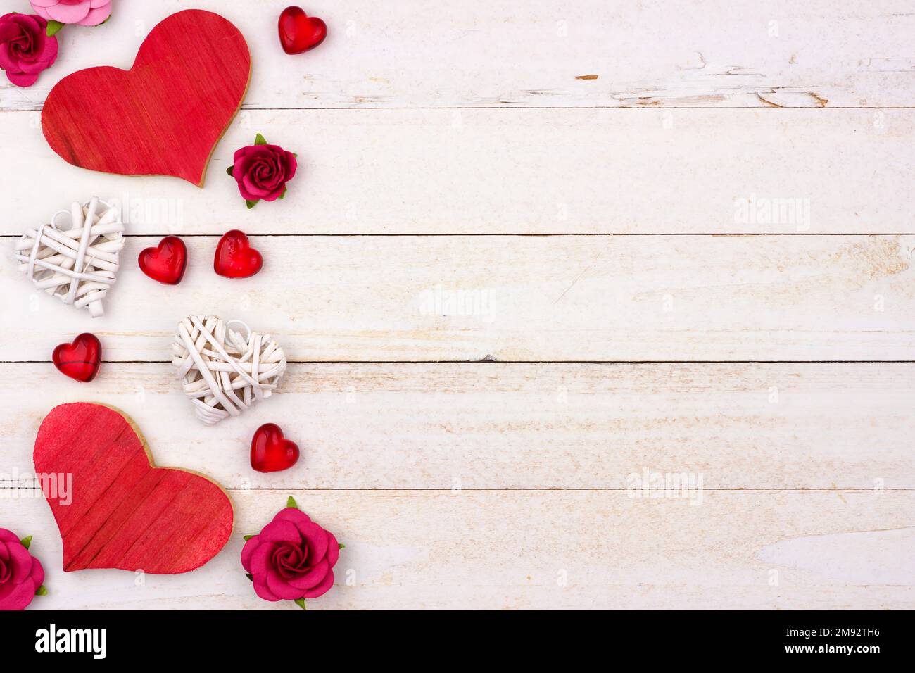 Valentines Day side border of hearts, flowers and decor against a ...