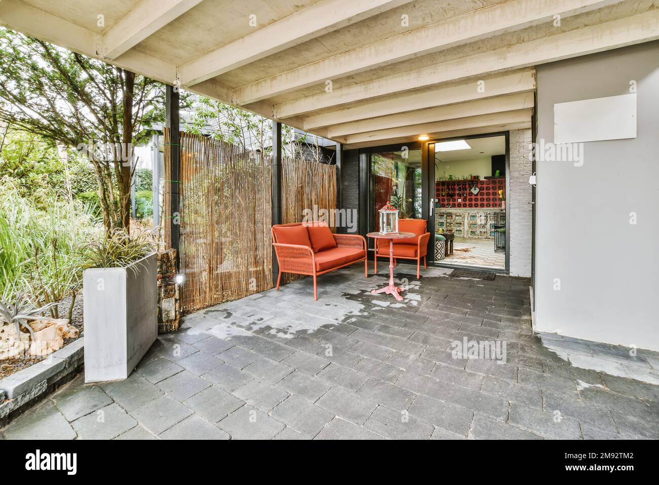 Orange sofa and armchair placed on terrace of modern house with stony ...