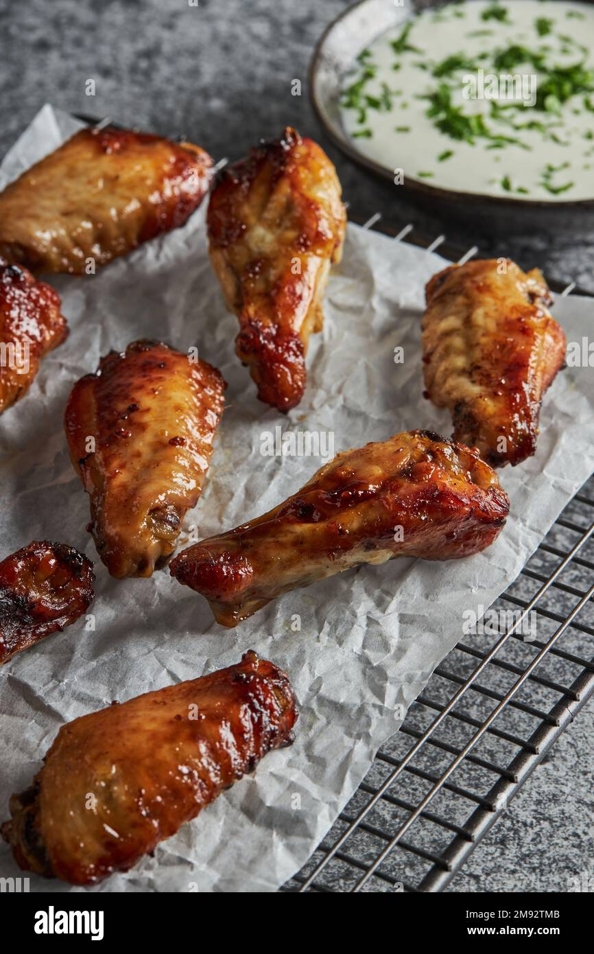 High angle of buffalo chicken wings with pepper sauce served in metal ...