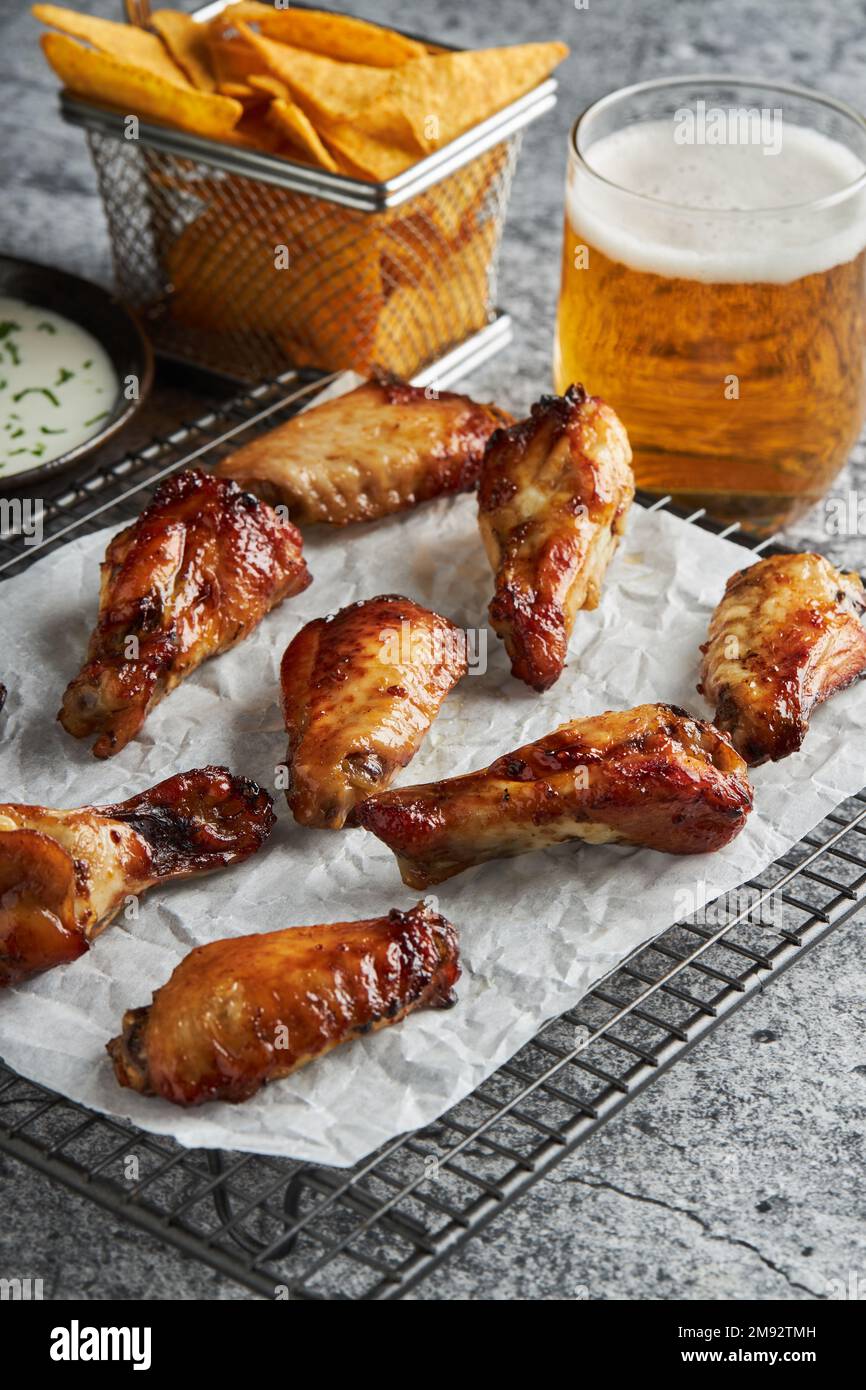 High angle of buffalo chicken wings with pepper sauce served with beer ...