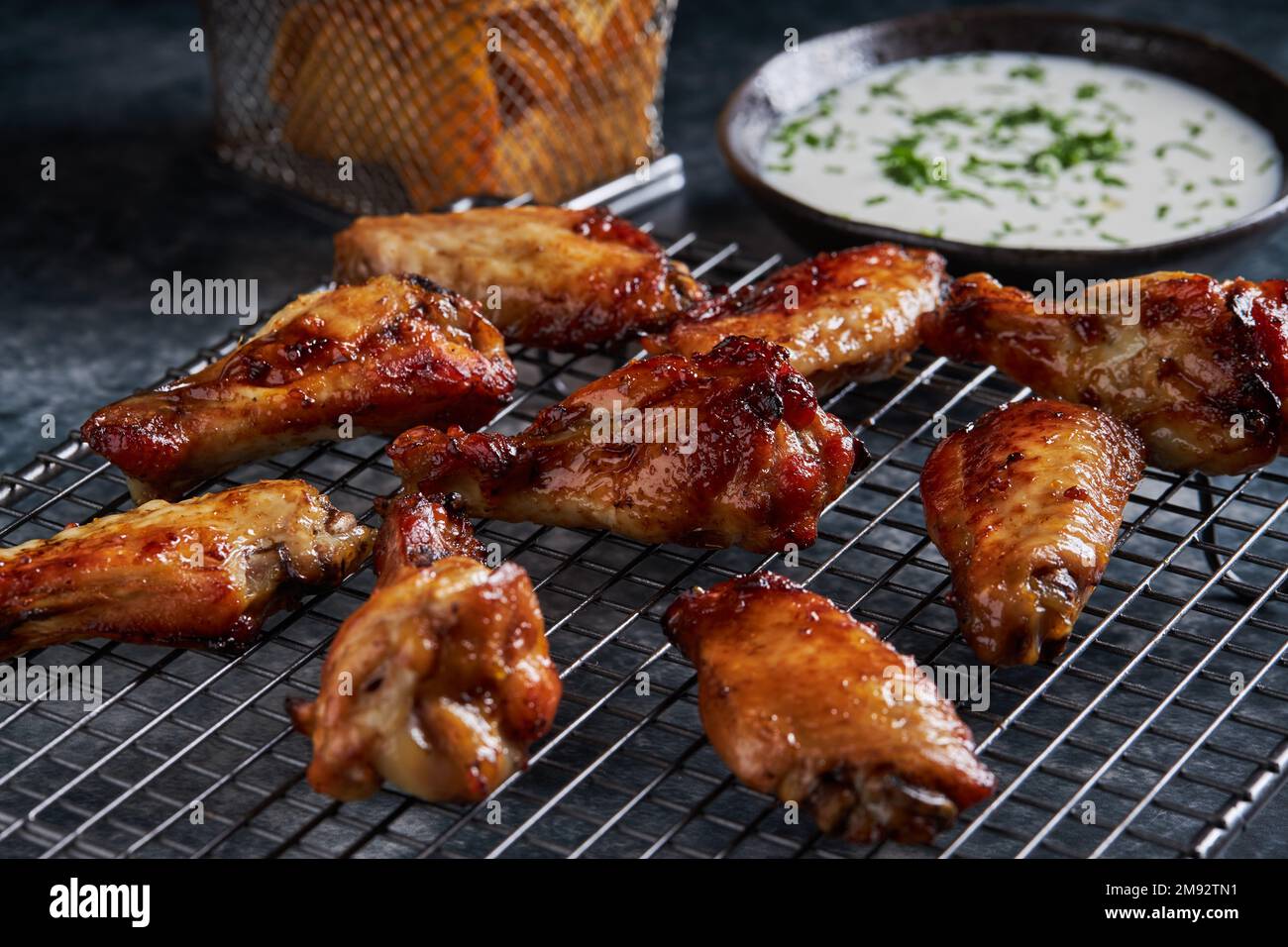 High angle of buffalo chicken wings with pepper sauce served with chips ...