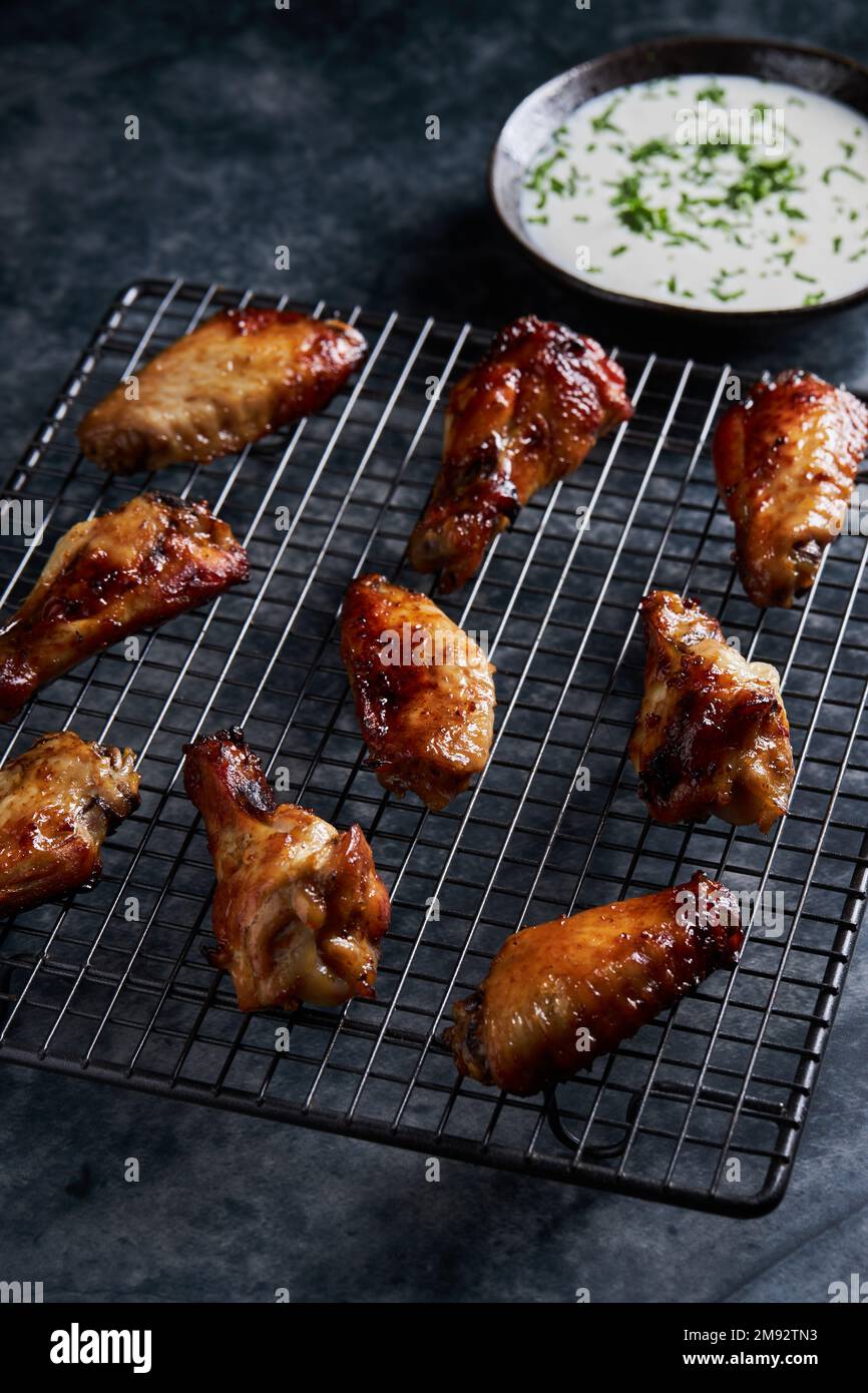 High angle of buffalo chicken wings with pepper sauce served in metal ...