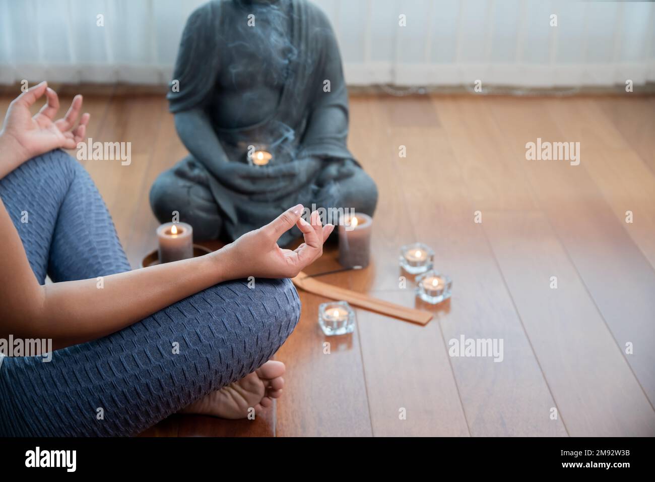 Crop anonymous female sitting in lotus pose with hands in Gyan mudra ...