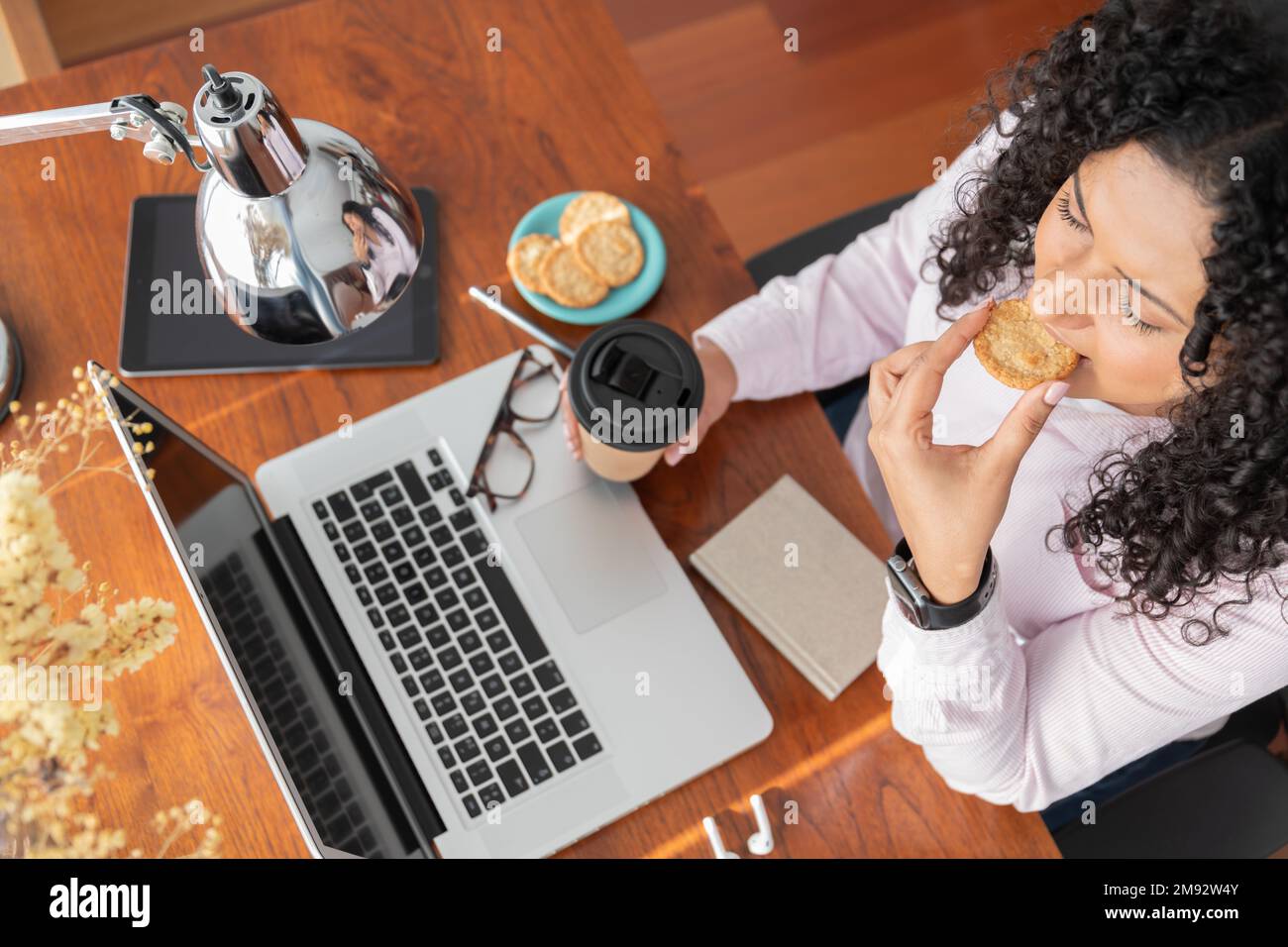 Woman eating biscuit in office hi-res stock photography and images - Alamy