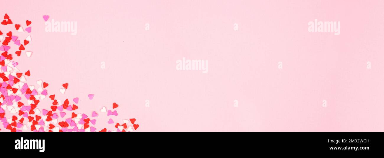Valentines Day corner border banner with candy heart sprinkles over a ...