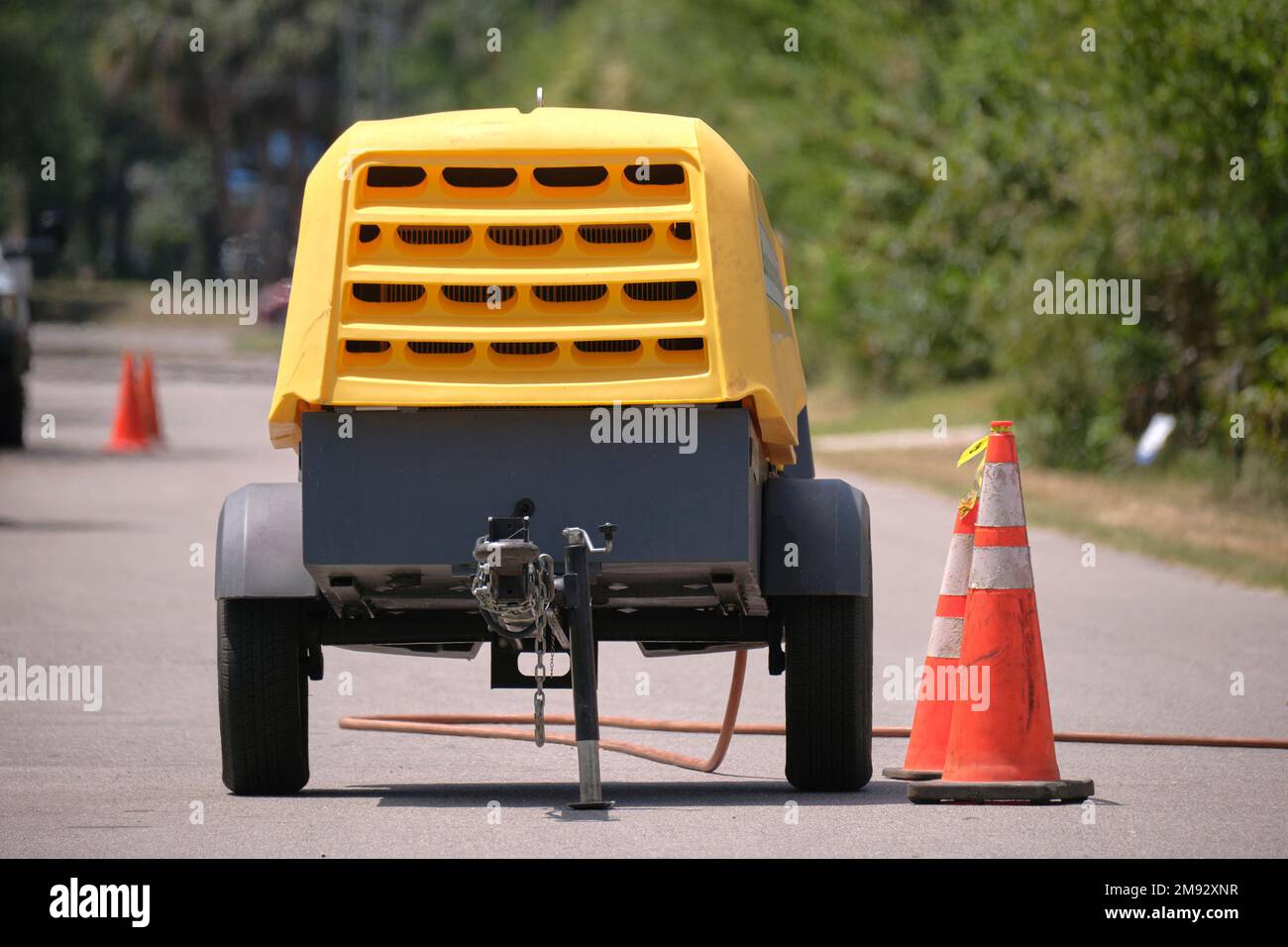 Yellow jackhammer machine with compressor trailer on road construction ...