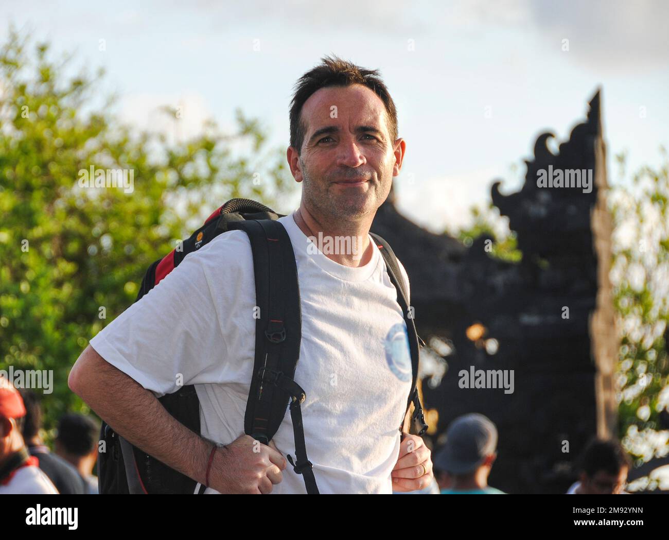 A tourist with a backpack visiting Bali while looking at camera Stock ...