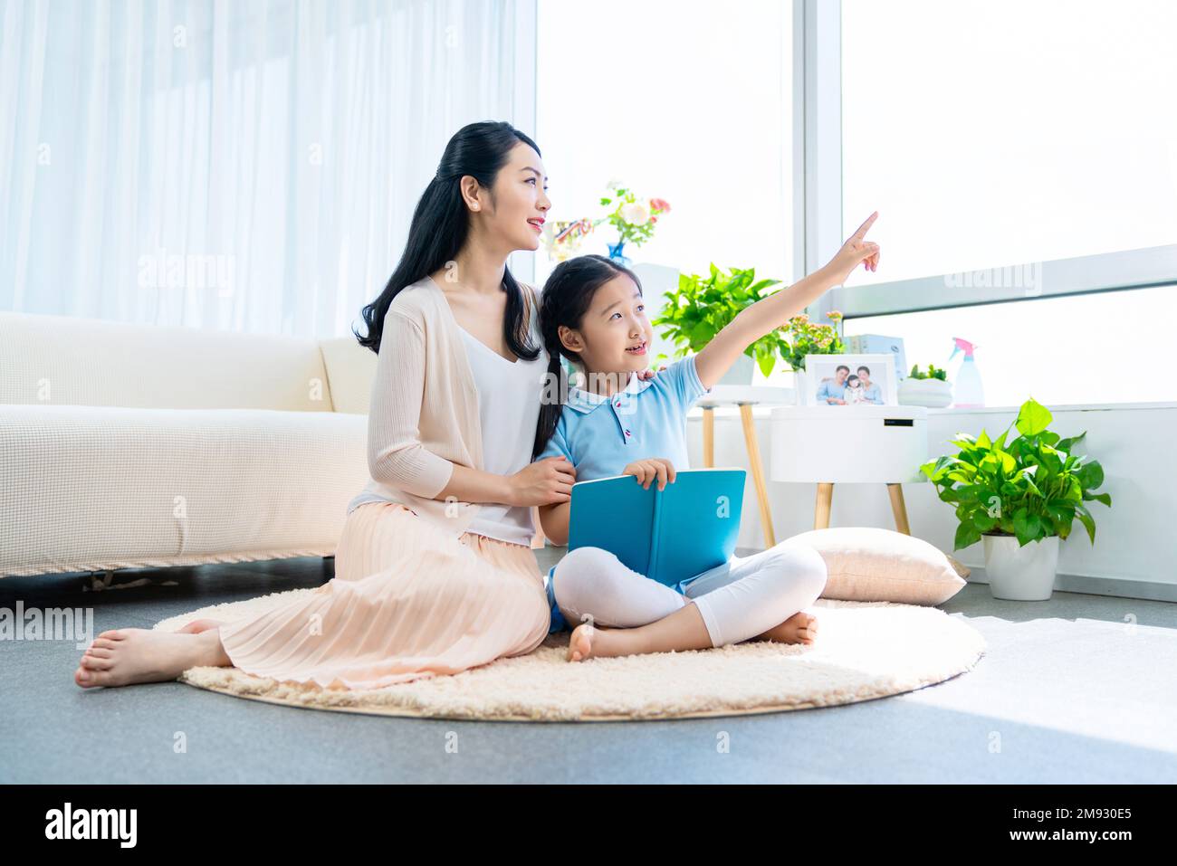 The little girl and her mother read a book together Stock Photo - Alamy