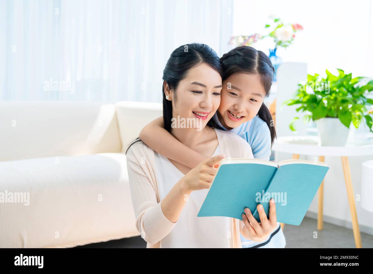 The little girl and her mother read a book together Stock Photo - Alamy
