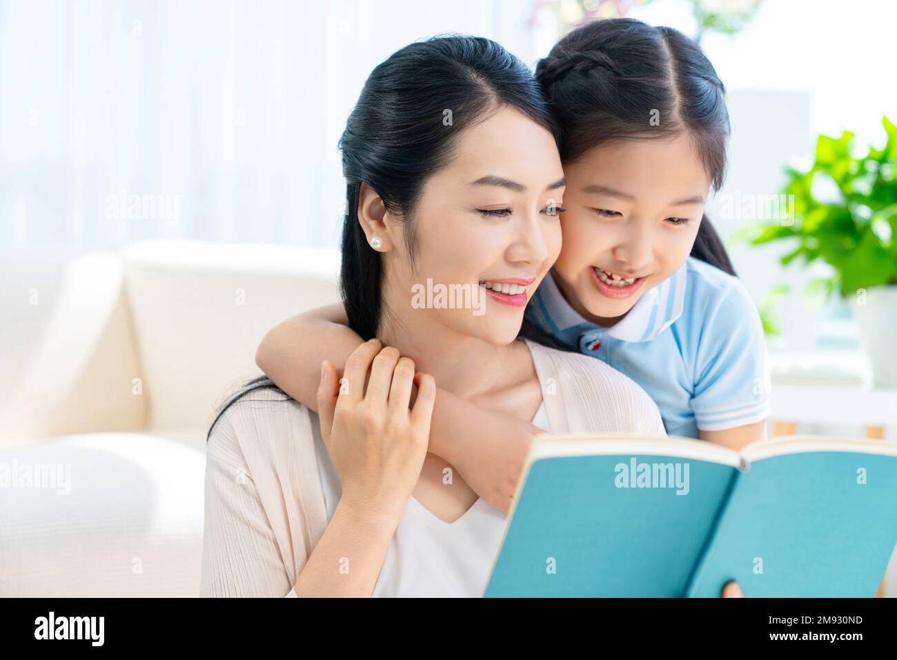 The little girl and her mother read a book together Stock Photo - Alamy