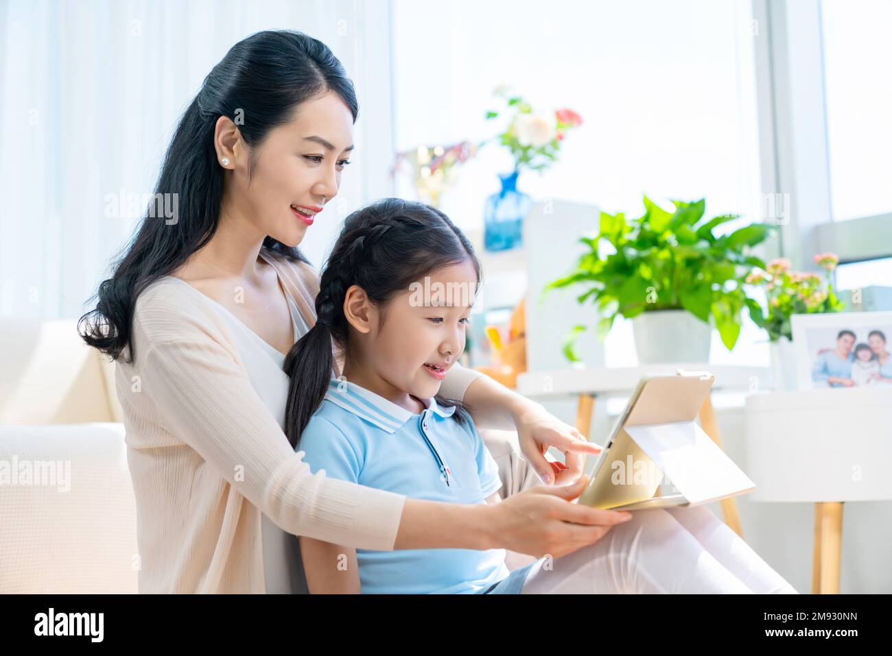 The little girl with her mother to use tablet Stock Photo - Alamy