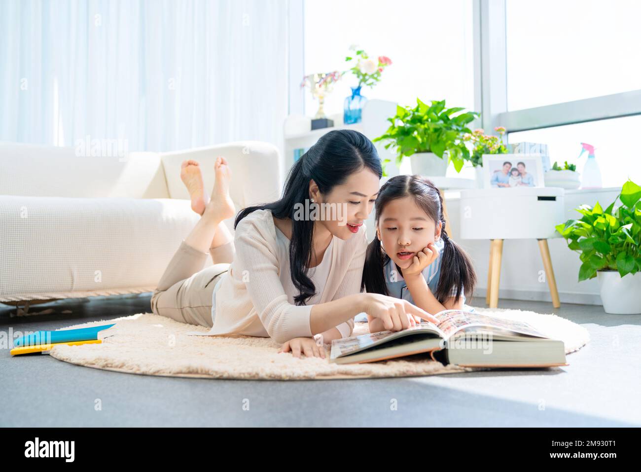 The little girl and her mother read a book together Stock Photo - Alamy