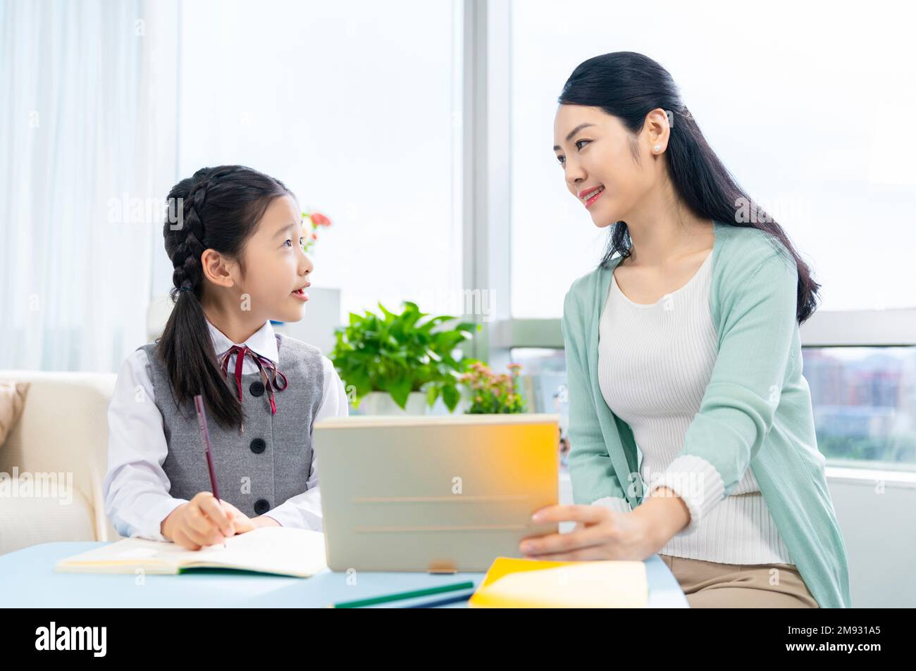 The little girl with her mother to use tablet Stock Photo - Alamy