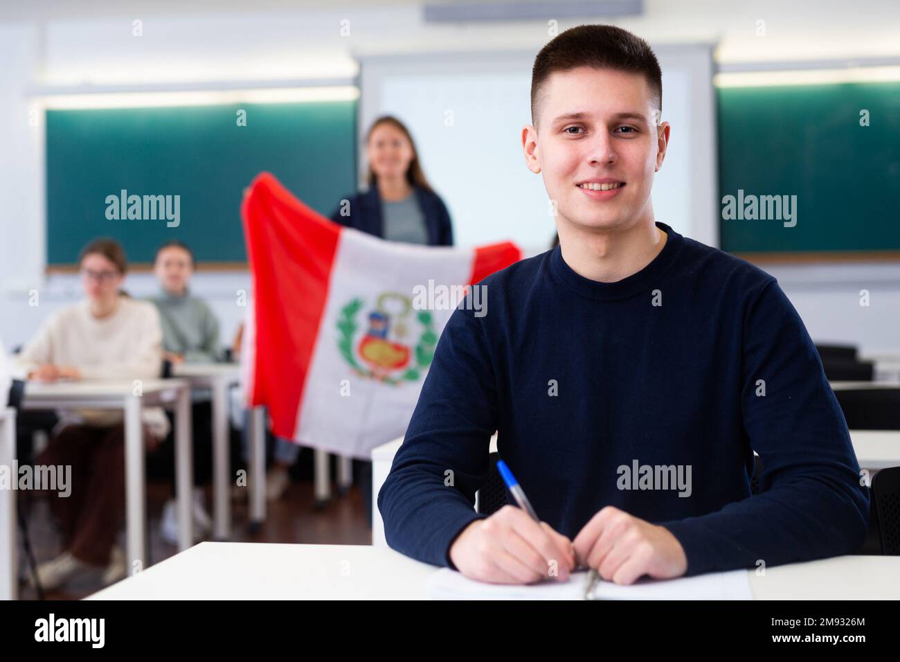 Teenage students in class and listening carefully to female teacher ...