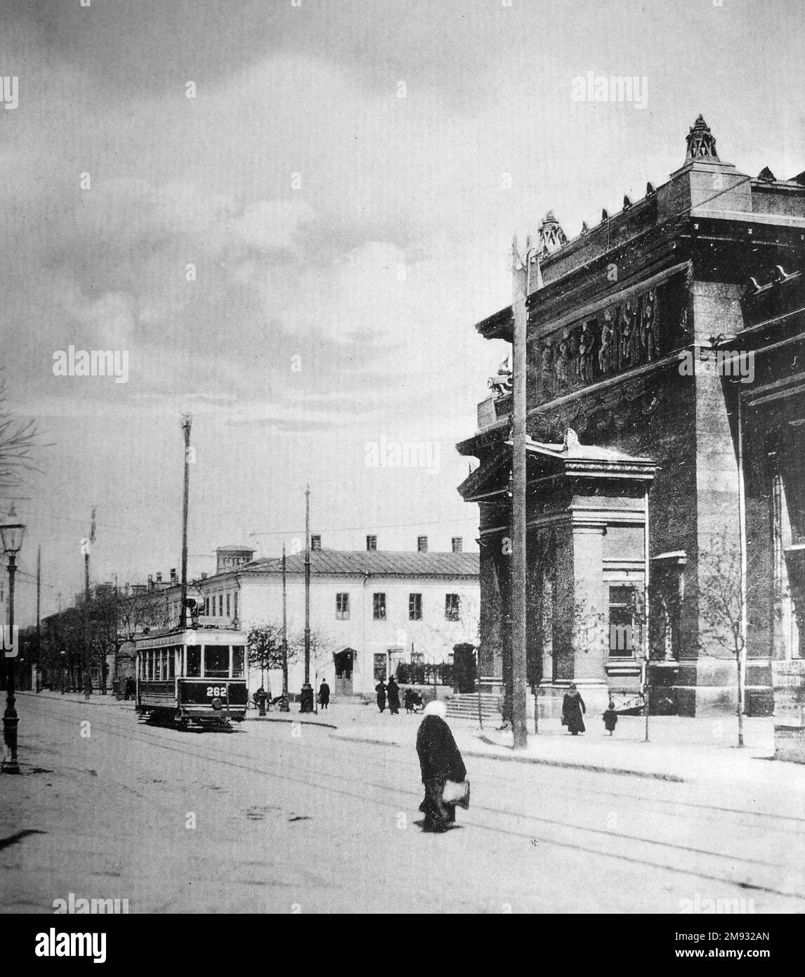 Trolley or tram in background, pedestrian in foreground, city scene of ...