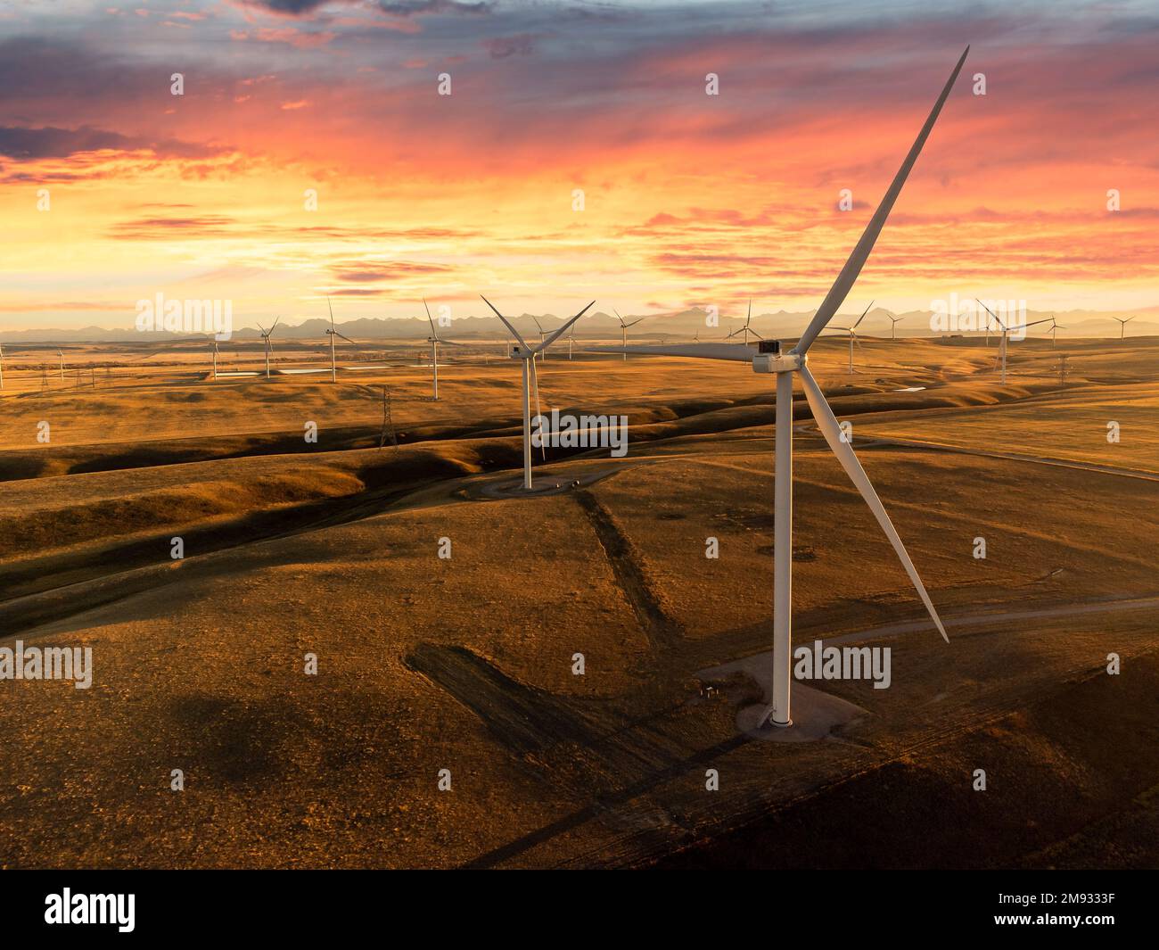 Aerial sunset windmills producing sustainable energy over natural ...