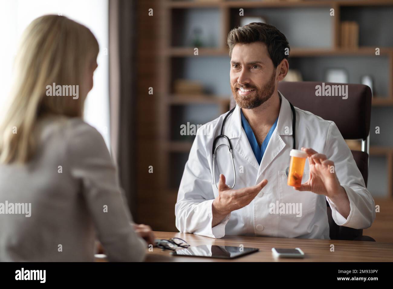Smiling Doctor Man Demonstrating Prescribing Medications To Female ...
