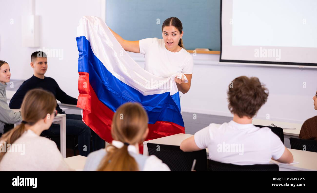 Adult female teacher showing Russian flag to students Stock Photo - Alamy