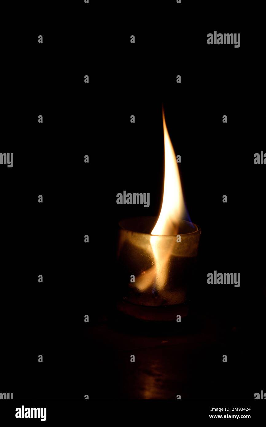 Burning Candle flame inside a glass surrounded by dark background Stock ...