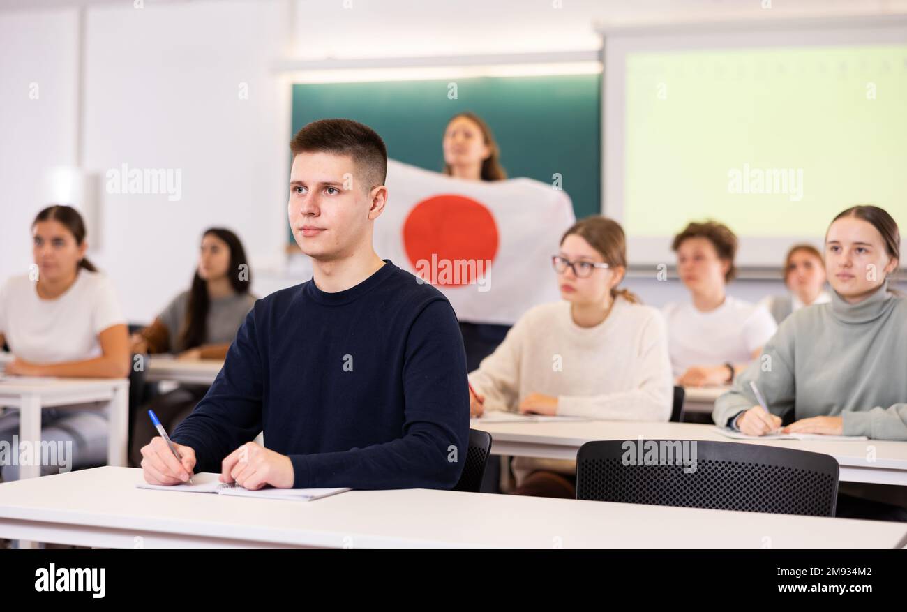 Teacher stands behind students with flag of Japan Stock Photo - Alamy