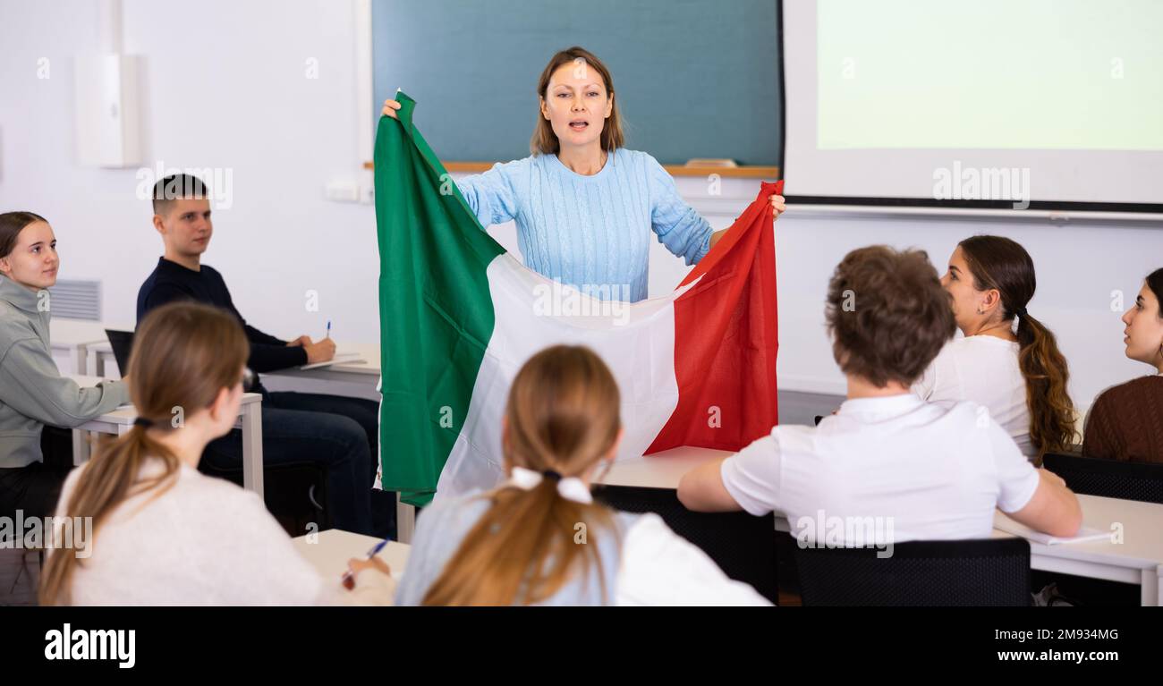 female professor shows students flag of Italy Stock Photo - Alamy
