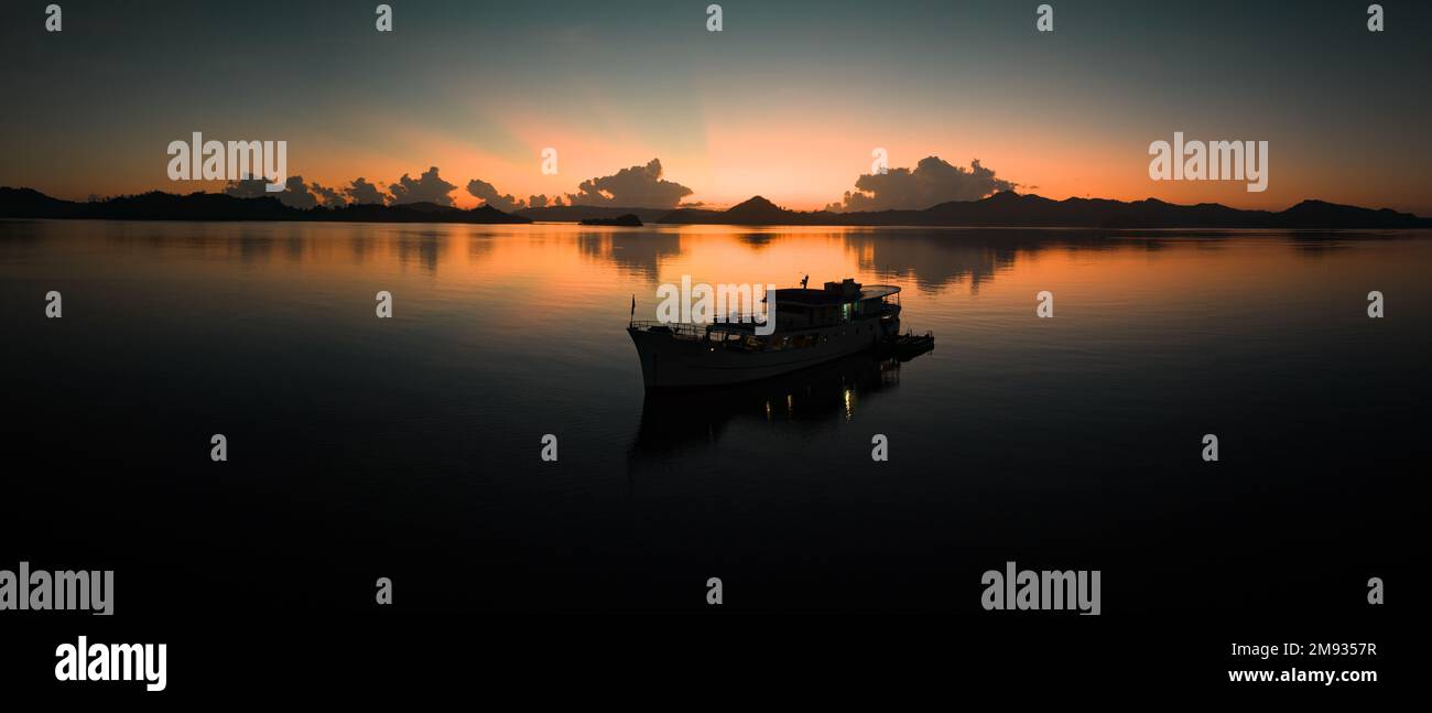 Sunrise illuminates the sky over the calm waters of the Solomon Islands ...