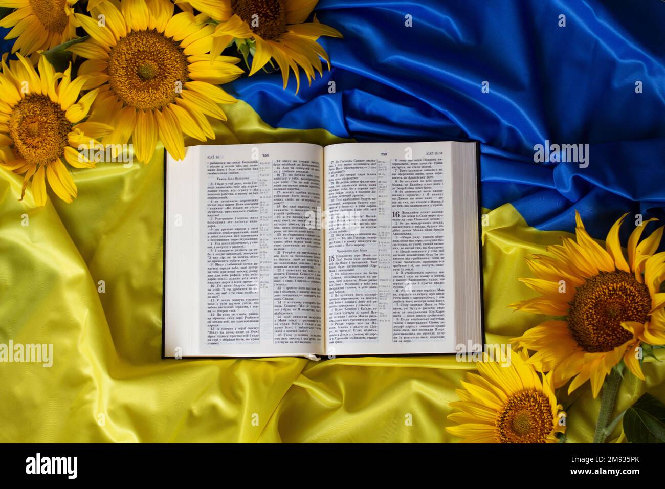 Bible (Holy Writ) and sunflowers on background of flag of Ukraine Stock ...