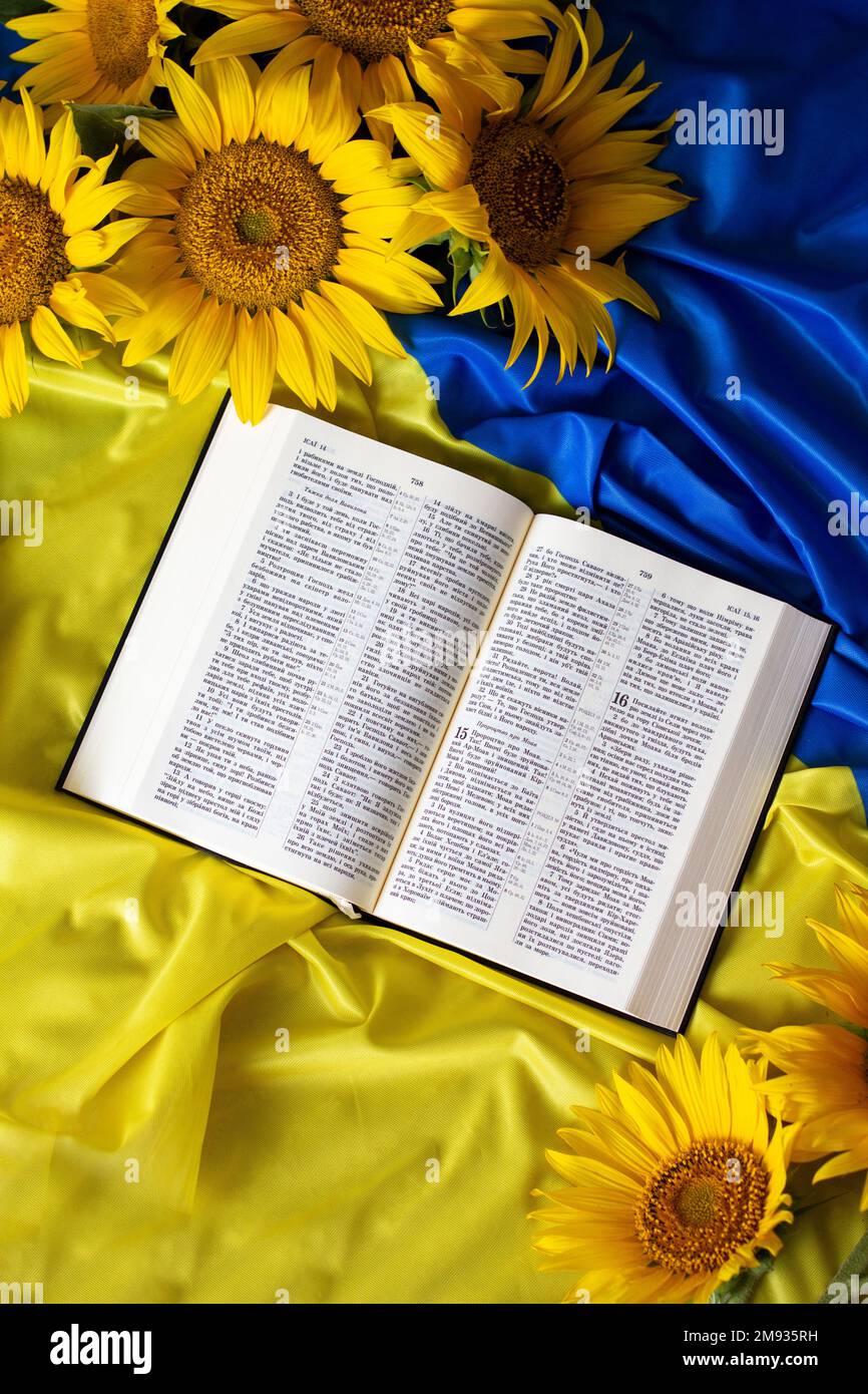 Bible (Holy Writ) and sunflowers on background of flag of Ukraine Stock ...