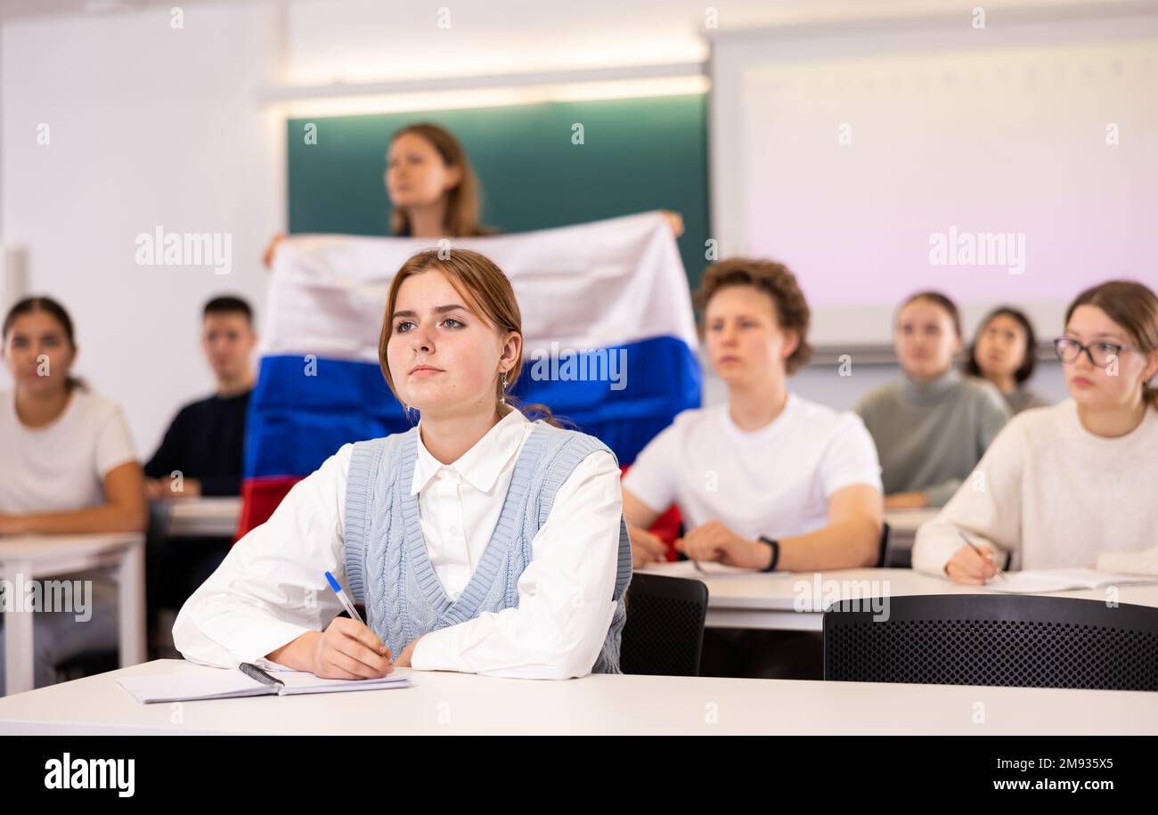 Teacher stands behind students with Russian flag Stock Photo - Alamy
