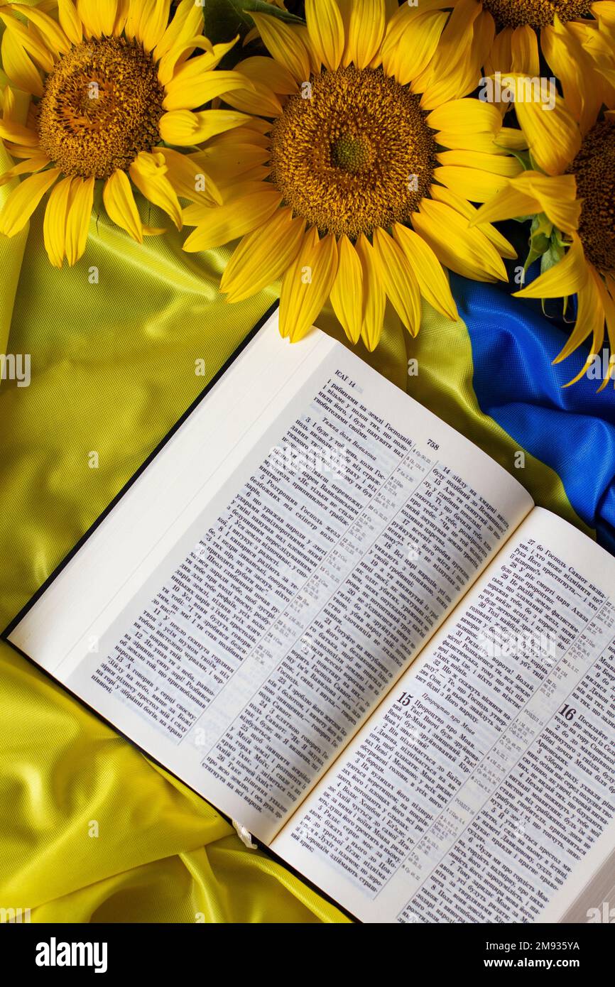 Bible (Holy Writ) and sunflowers on background of flag of Ukraine Stock ...