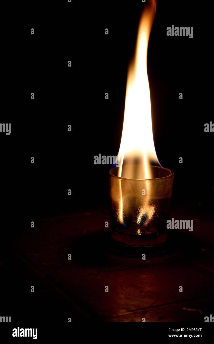 Burning Candle flame inside a glass surrounded by dark background Stock ...