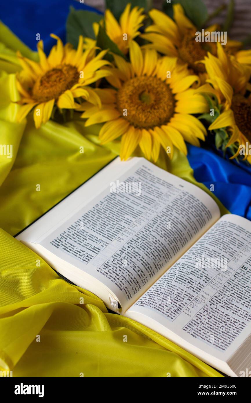 Bible (Holy Writ) and sunflowers on background of flag of Ukraine Stock ...