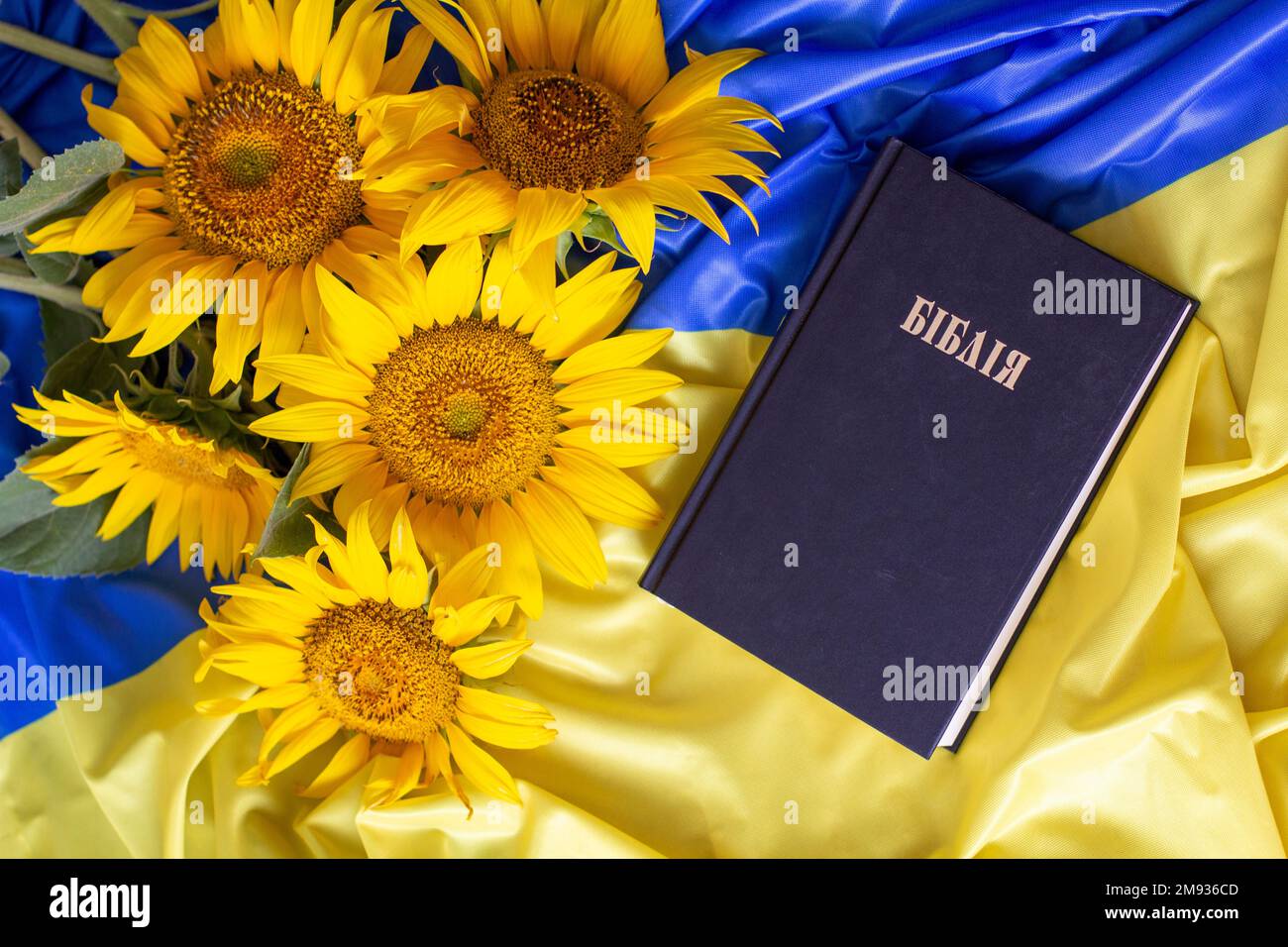 Bible (Holy Writ) and sunflowers on background of flag of Ukraine Stock ...