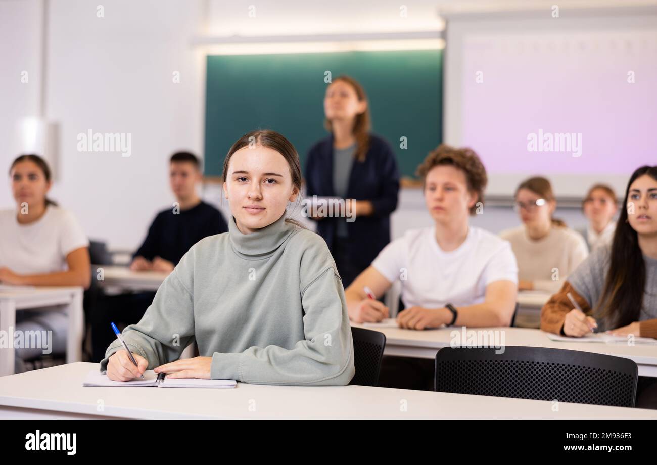 Female student sit at desk and makes notes Stock Photo - Alamy