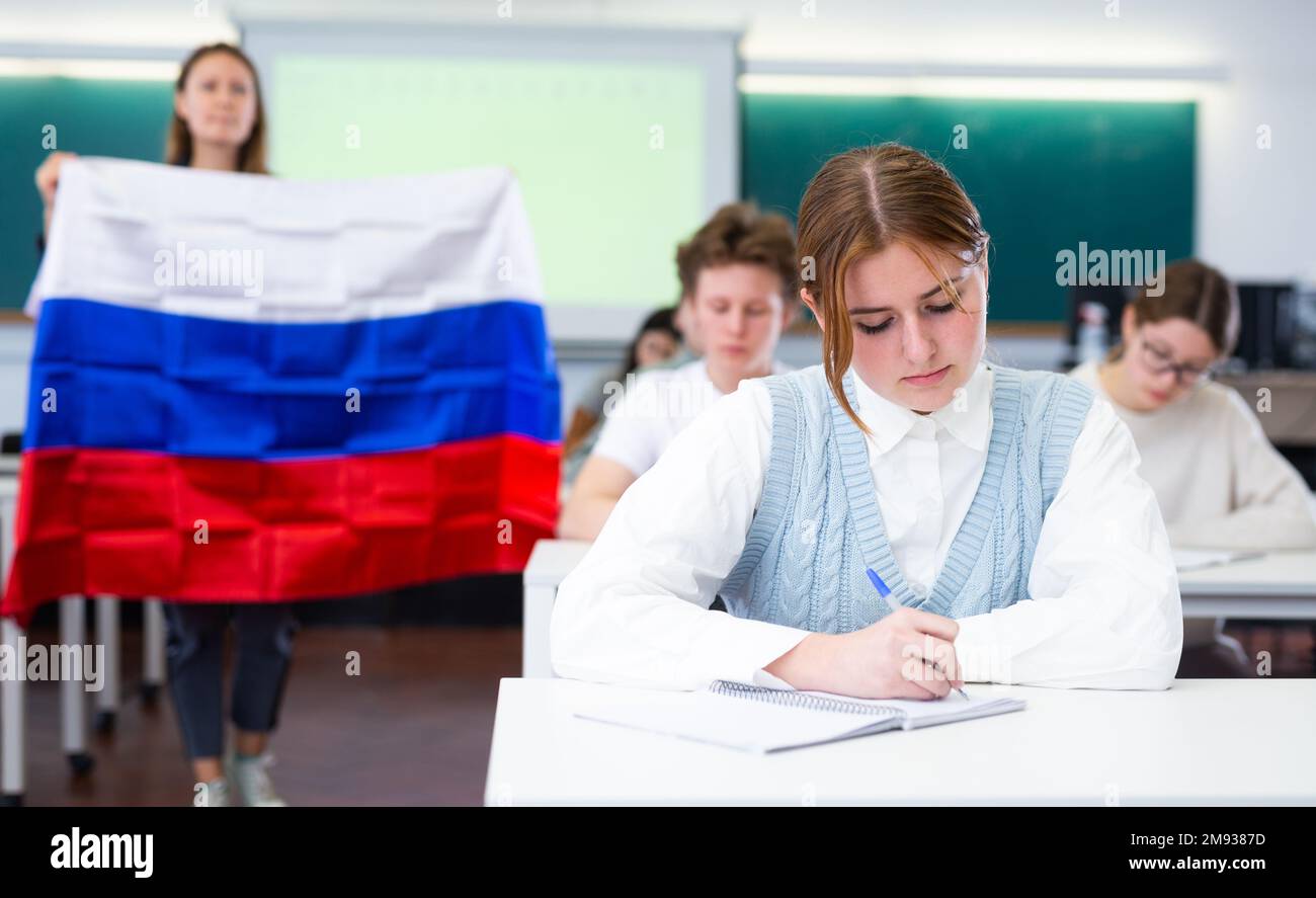 Teacher stands behind students with Russian flag Stock Photo - Alamy