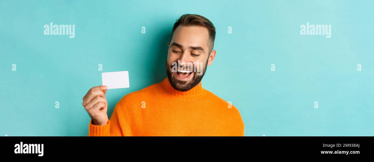Close-up of handsome caucasian man going on shopping, showing credit ...